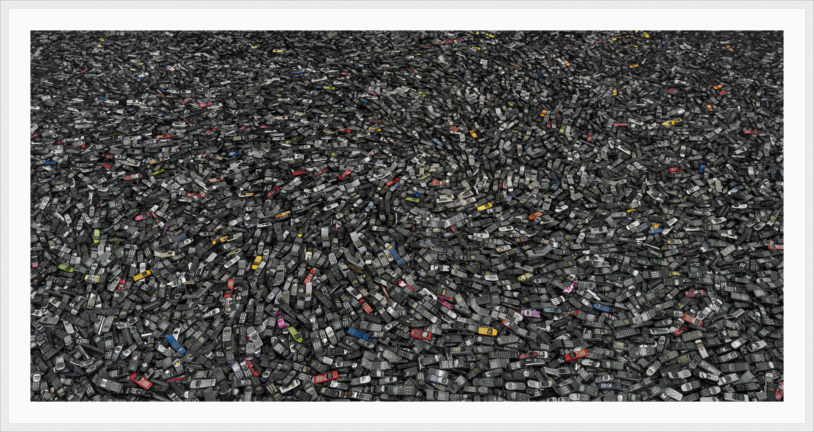 Photograph of thousands of cell phones waste consumerism e-waste